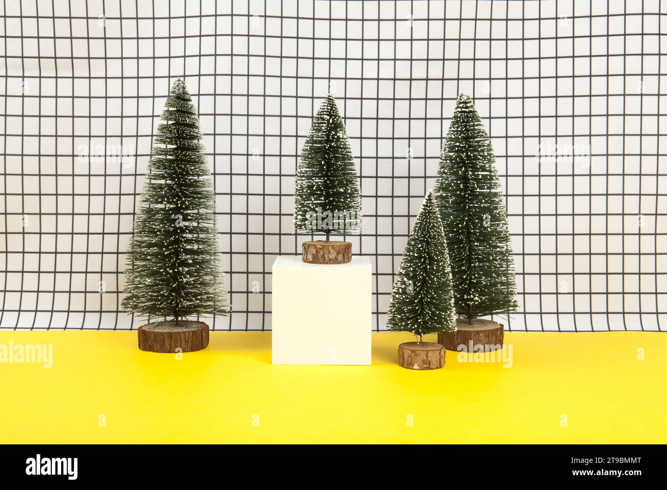 a white wooden cube surrounded by several miniature christmas trees on ...