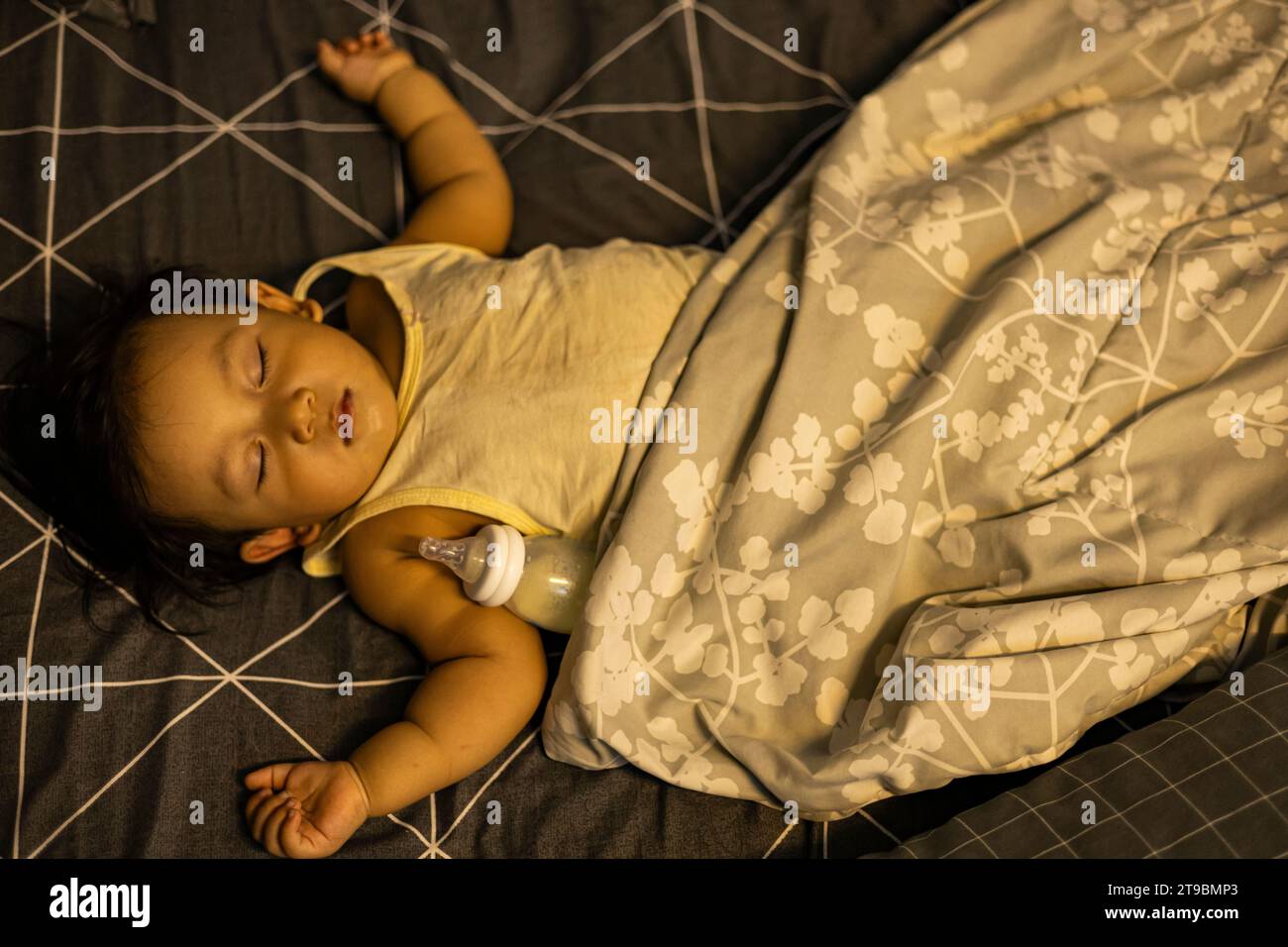 adorable Asian baby sleeping drinking milk from the bottle alone on the bed Stock Photo - Alamy