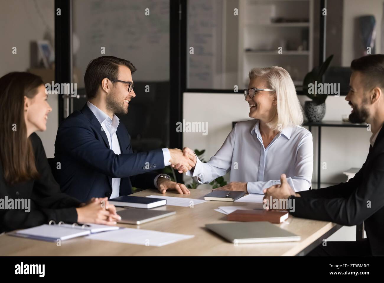 Positive senior business leader woman giving handshake to effective ...