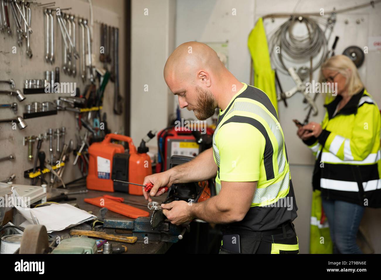 Male and female colleagues working in workshop Stock Photo - Alamy