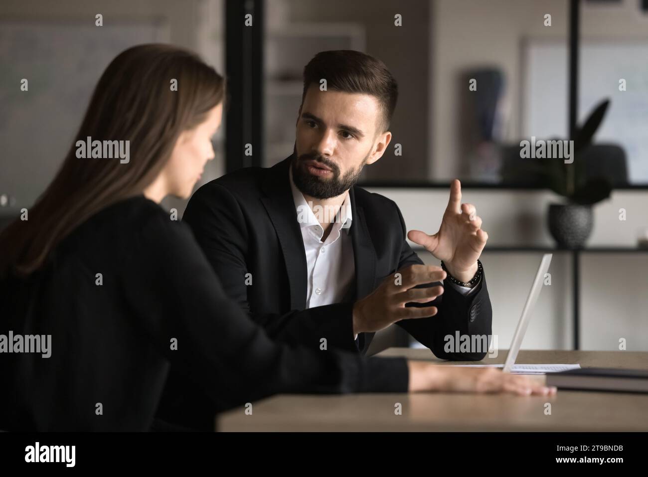 Busy young managers talking at workplace, discussing cooperation Stock ...