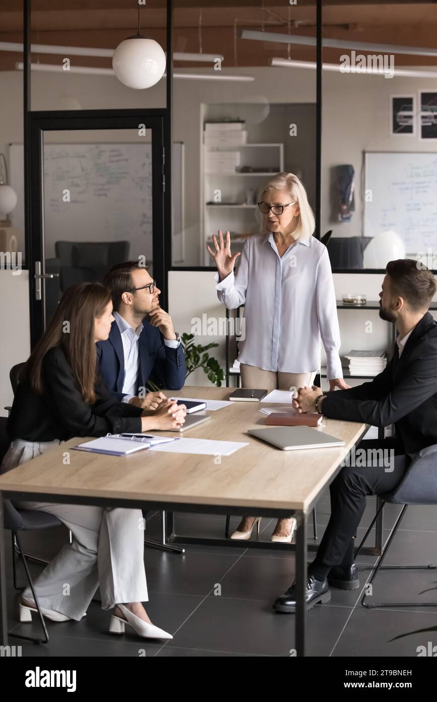 Serious senior boss woman talking to group of workers Stock Photo - Alamy