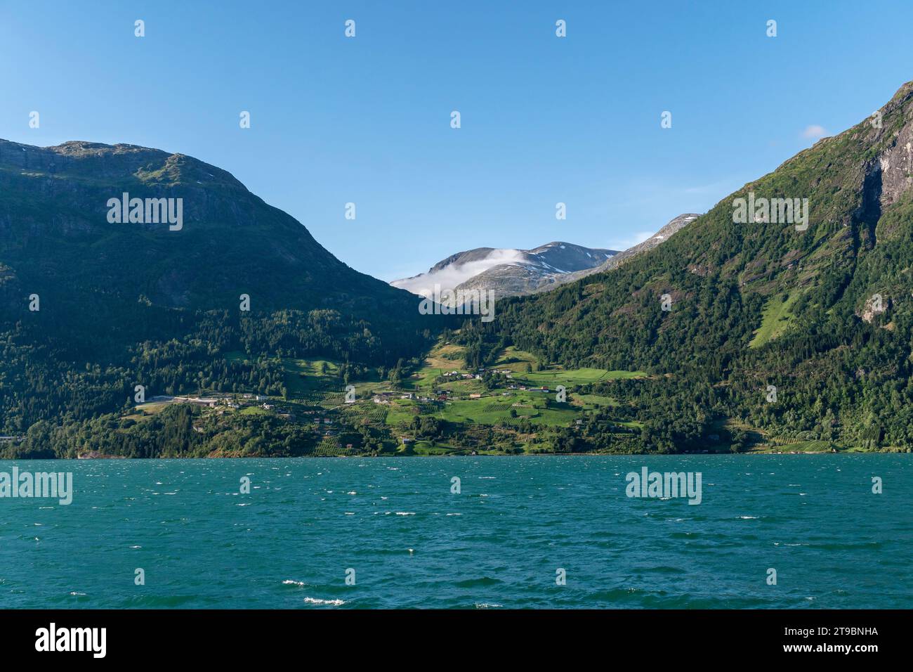 Blue sky over mountains at sea Stock Photo - Alamy
