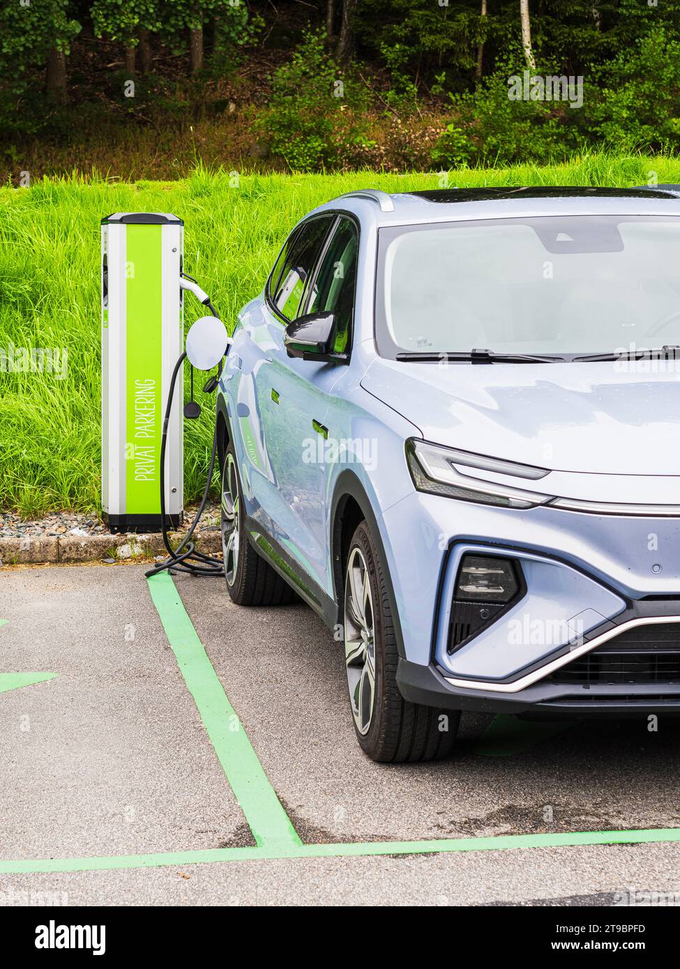 Electric car connected to charger Stock Photo - Alamy
