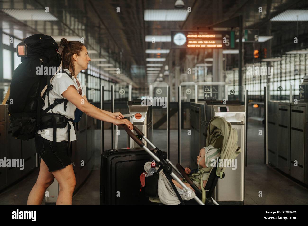 Mother with baby in stroller at train station Stock Photo - Alamy
