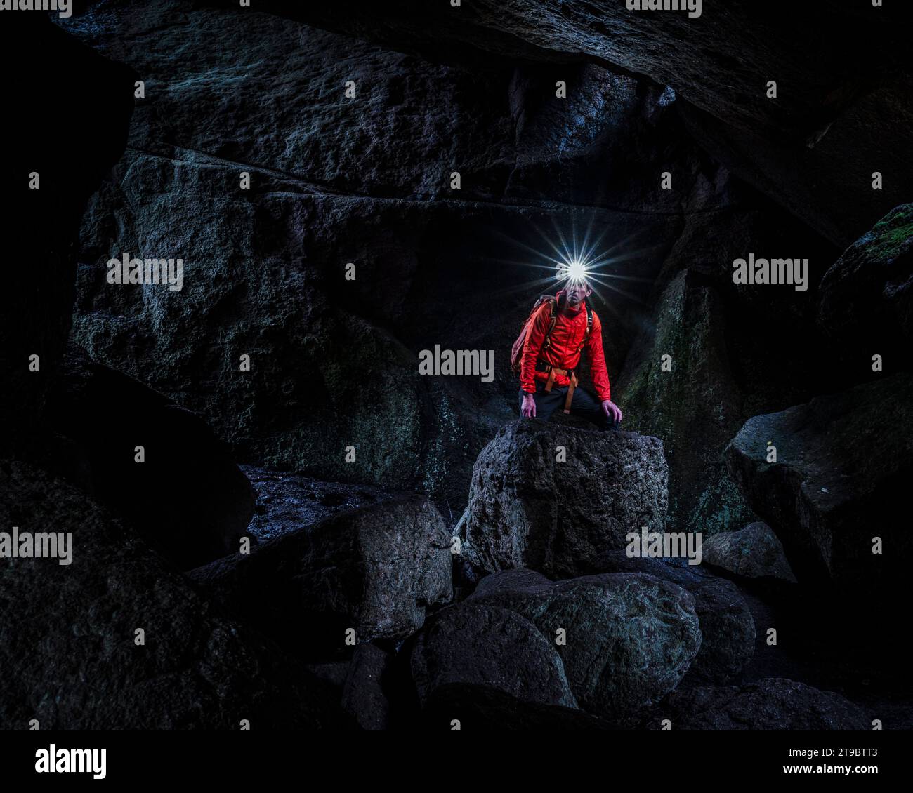 Man with headlamp exploring cave Stock Photo - Alamy