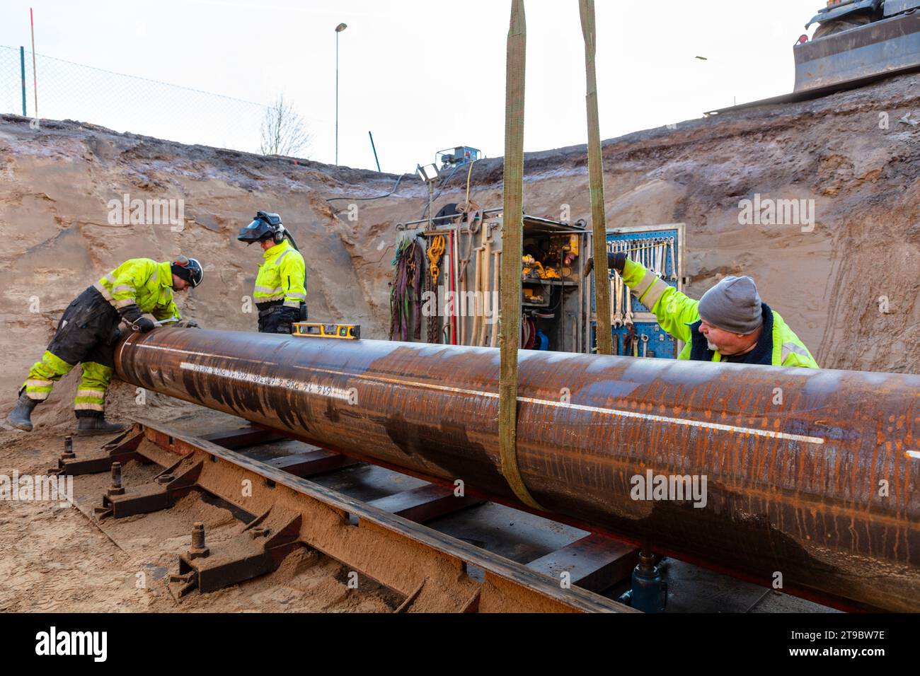Metal workers working amidst iron pole at construction site Stock Photo ...