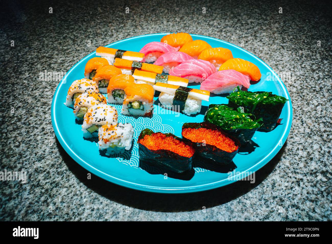 Japanese Sushi and Sashimi menu set on a large blue plate on the marble ...