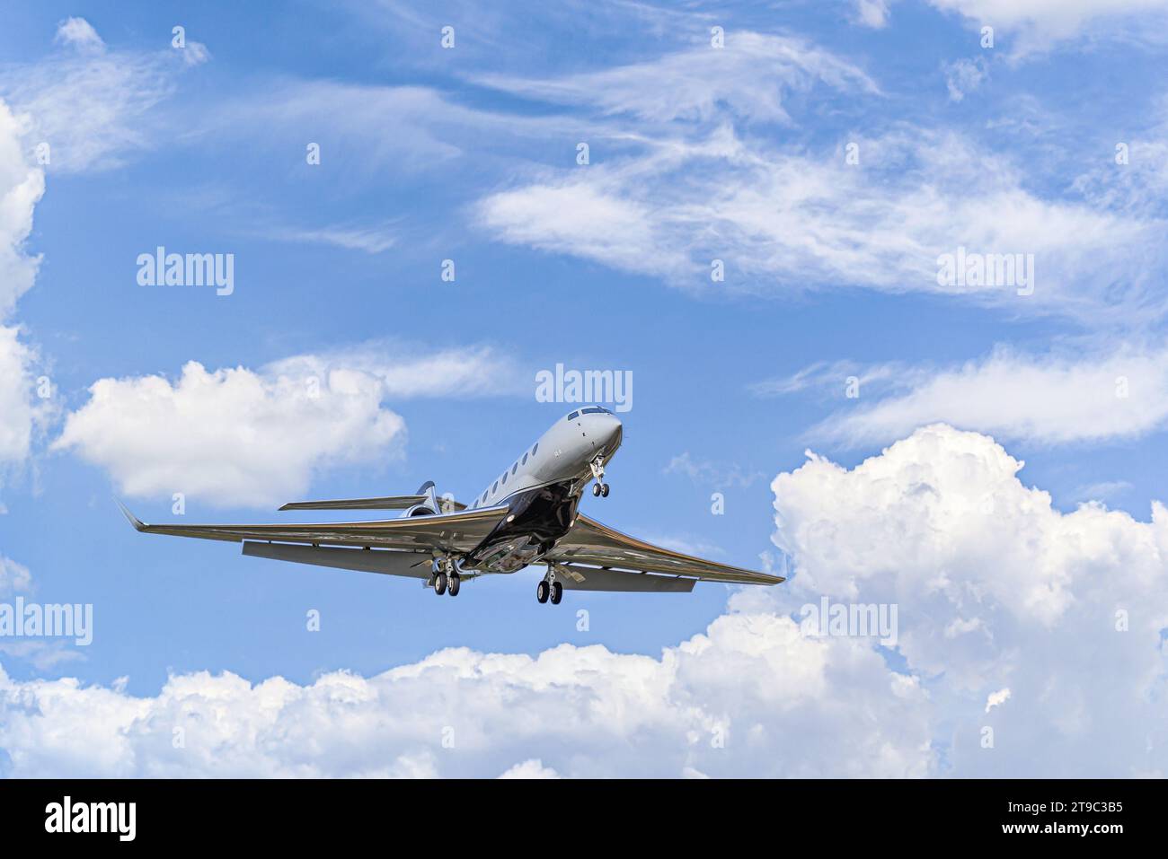 Private business plane flying under a blue sky with white clouds Stock ...