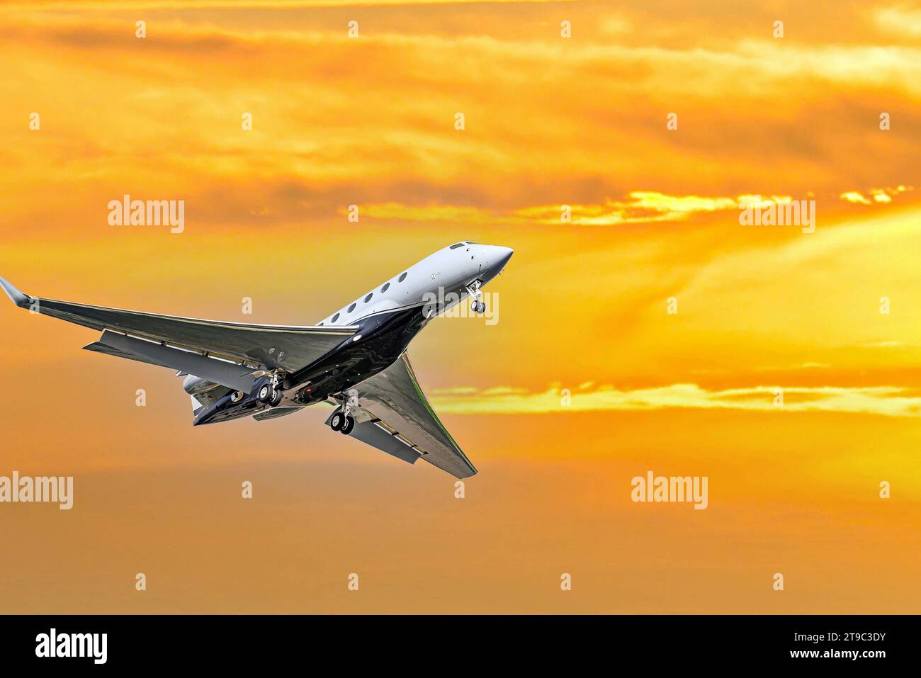 Private business plane flying under orange sunset sky Stock Photo - Alamy