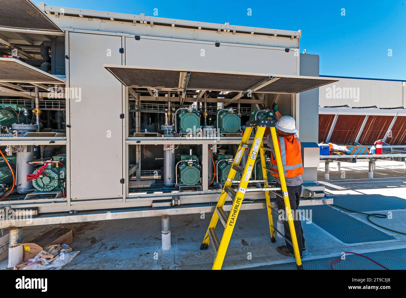 Construction worker works inside a compressor housing with open doors ...