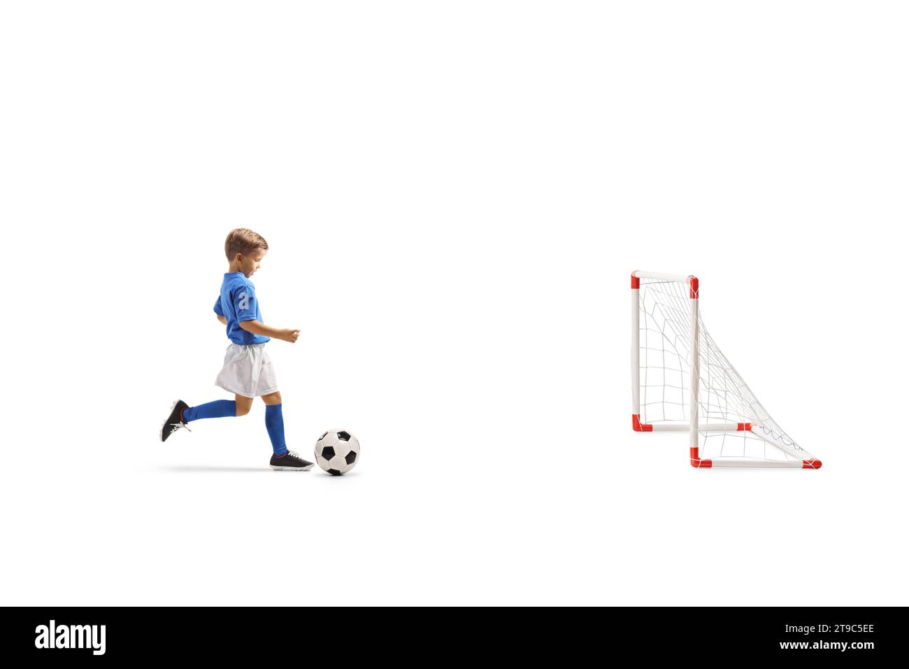 Full length profile shot of a boy with soccer ball running towards a ...