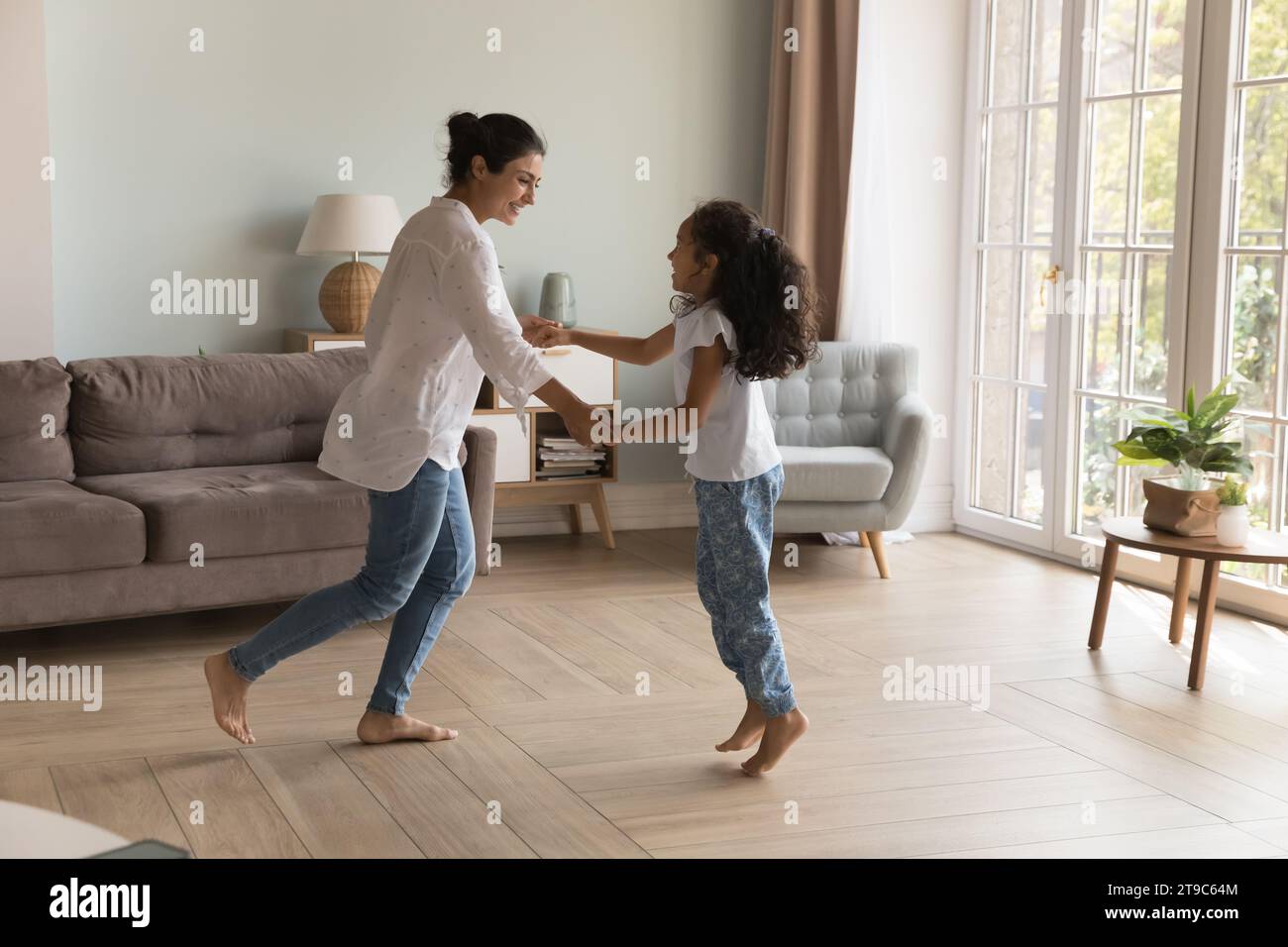 Young mother and little daughter holds hands dancing at home Stock ...