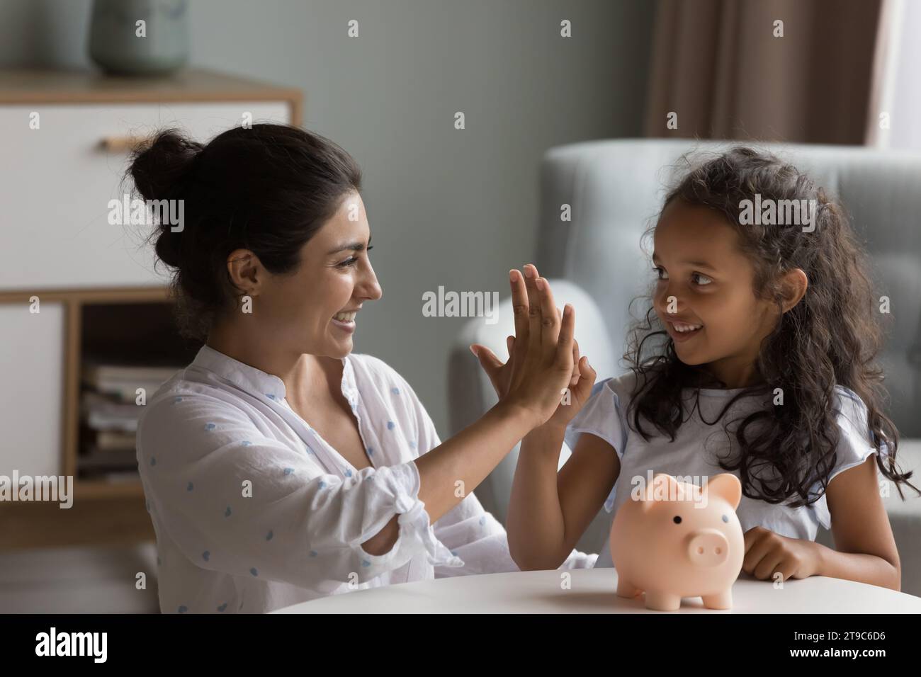 Mom teach daughter save money giving high five feel happy Stock Photo ...