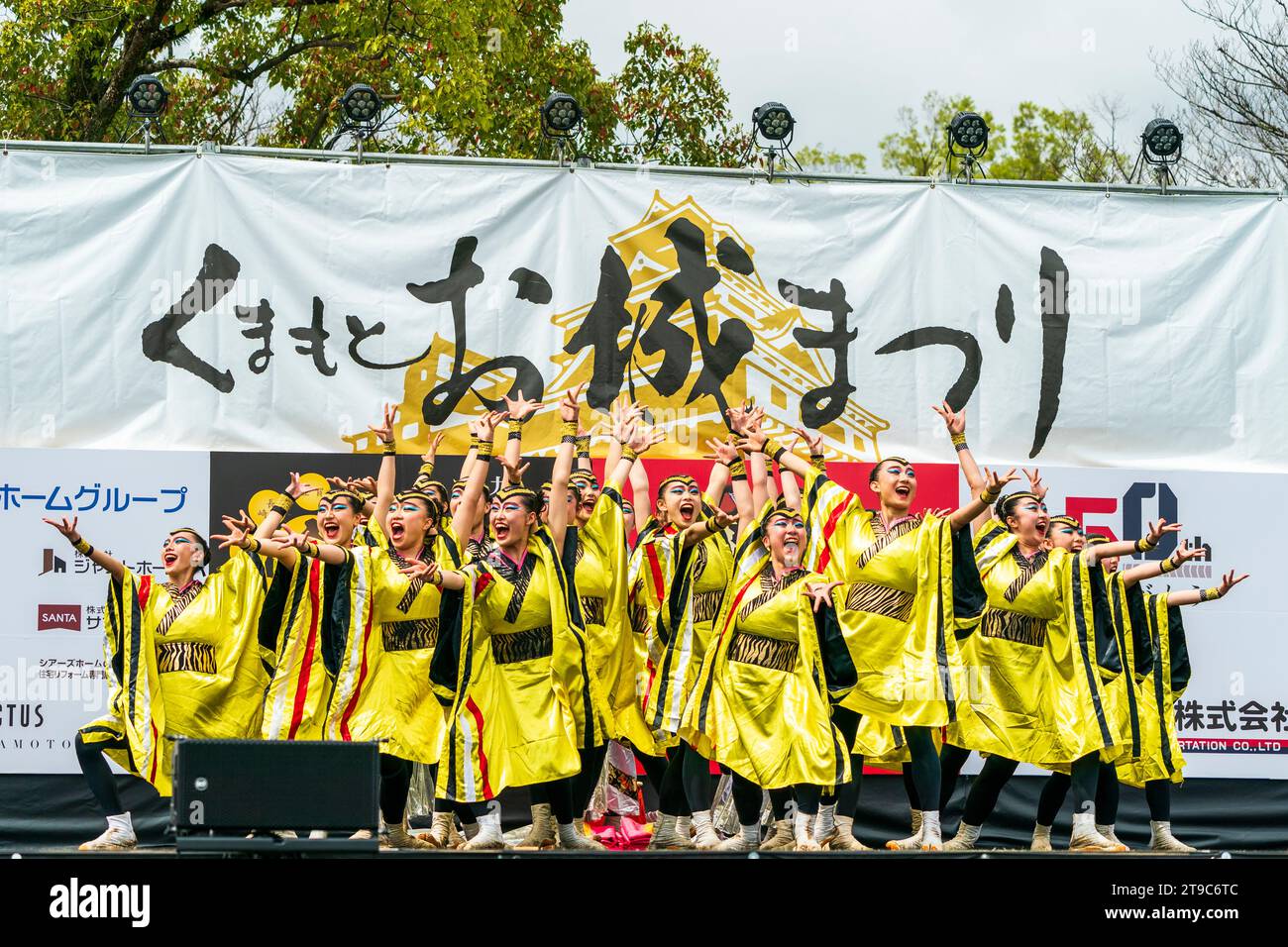 Japanese teenage women Yosakoi dance team in yellow and black costumes ...