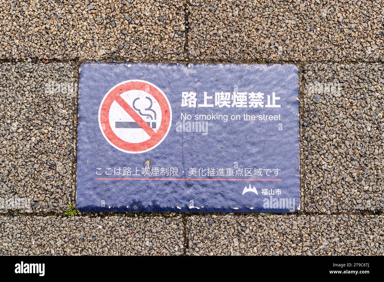 Sign on the pavement in Fukuyama in both English and Japanese stating ...