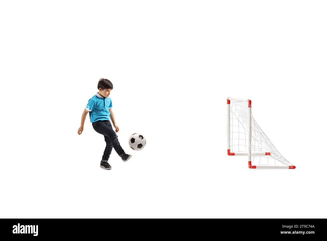 Full length shot of a little boy playing soccer with a mini goal ...