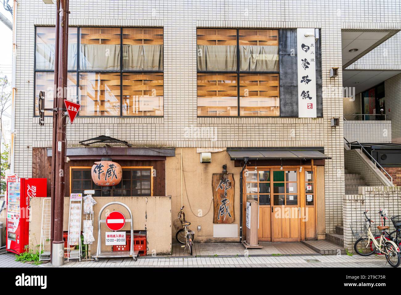 Two story Japanese restaurant in a white brick building. Entrance, name ...