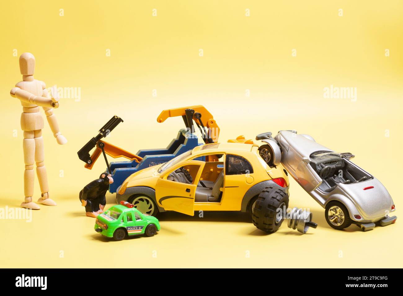 Car crash accident and wooden artist mannequin on a yellow background ...