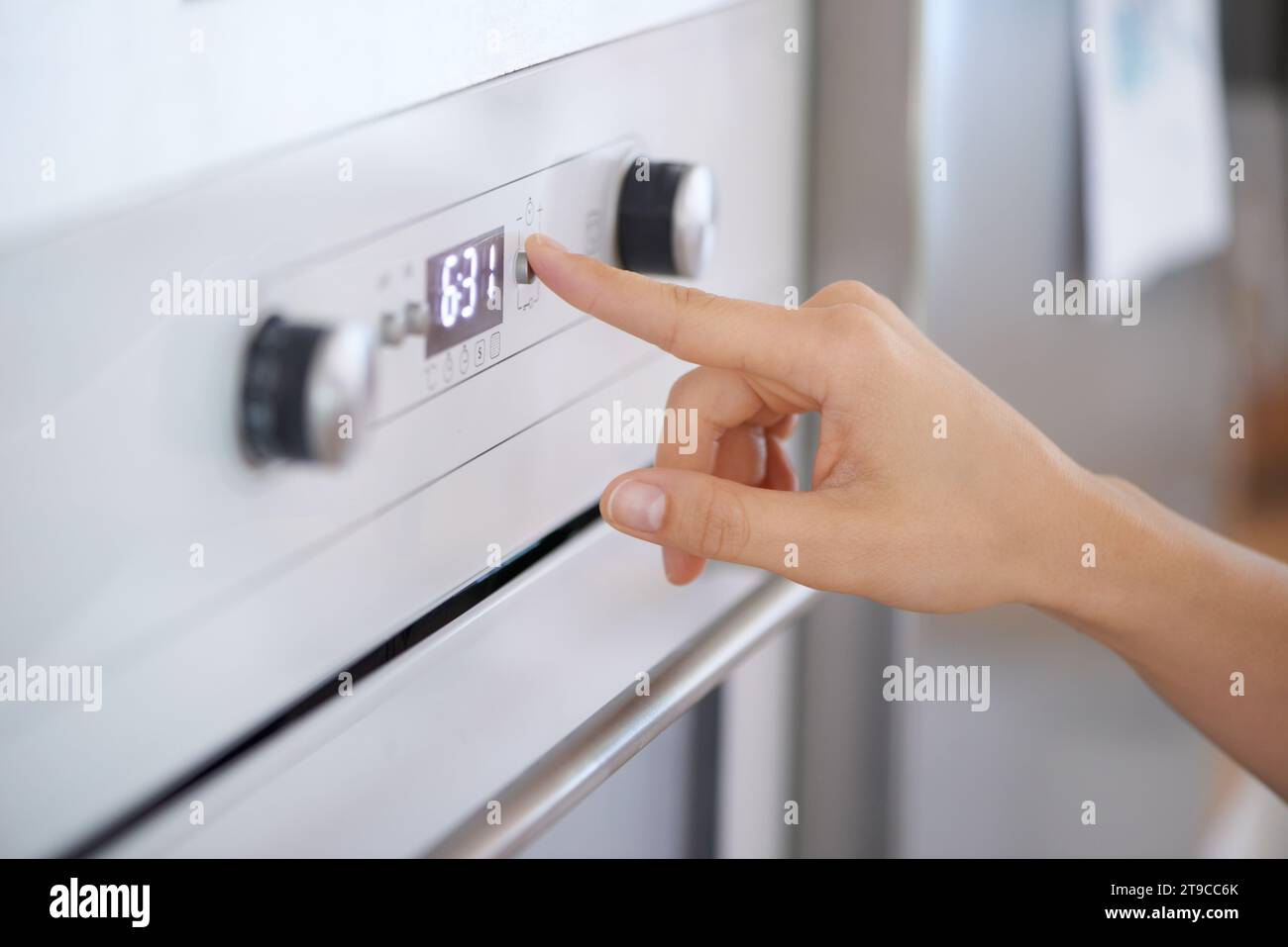 Closeup, hand and button on oven for cooking in kitchen for heating ...