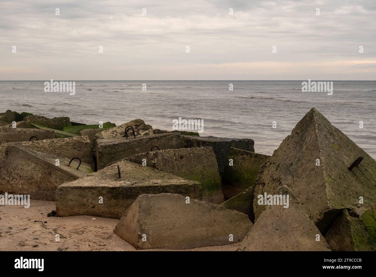 Manmade sentinels line the shoreline—stacked concrete blocks stand ...