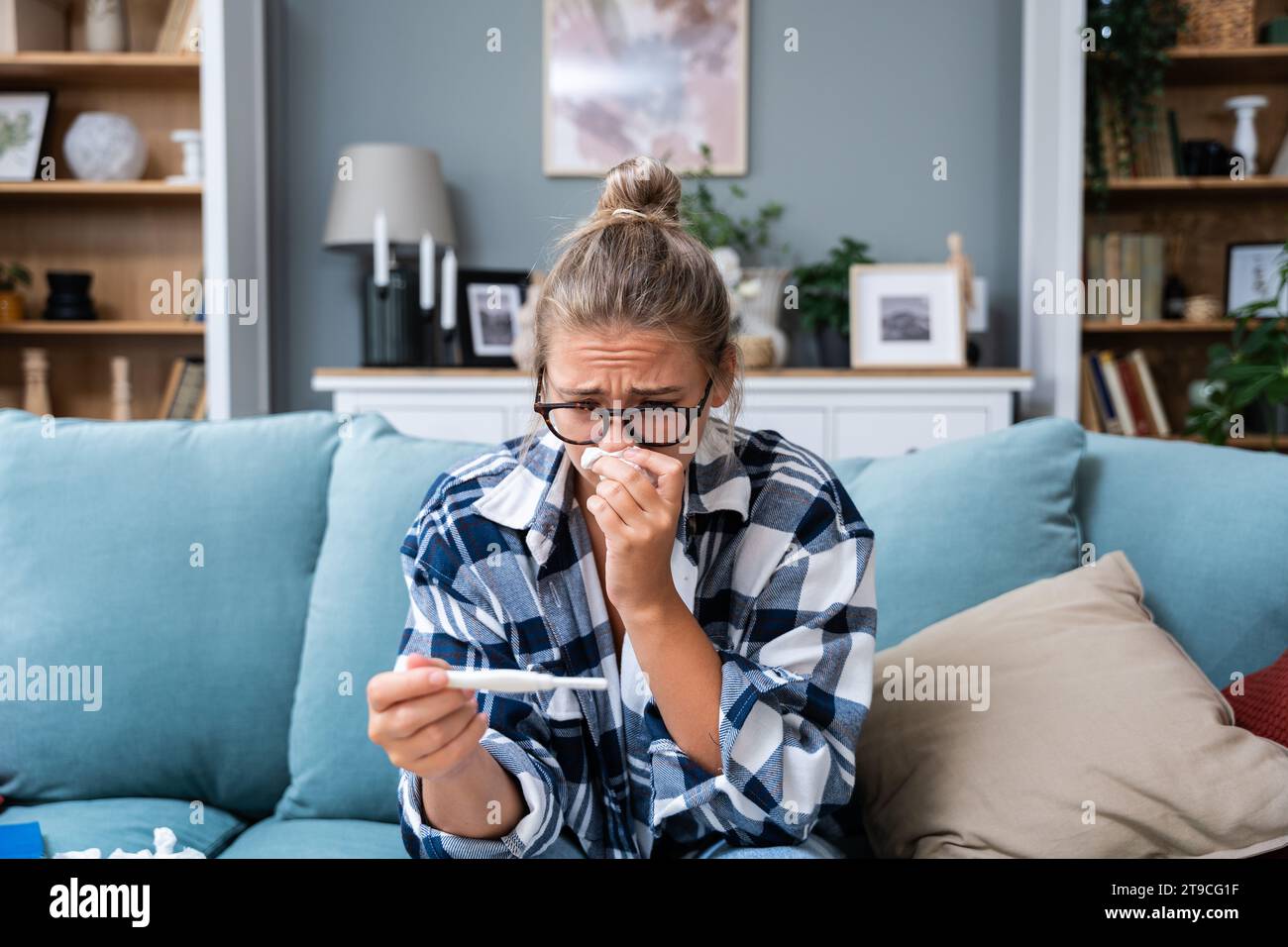 Single sad woman complaining holding a pregnancy test sitting on a ...