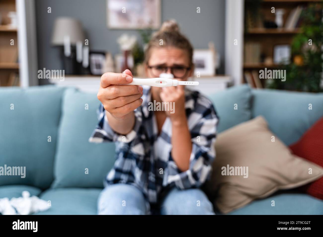 Single sad woman complaining holding a pregnancy test sitting on a ...