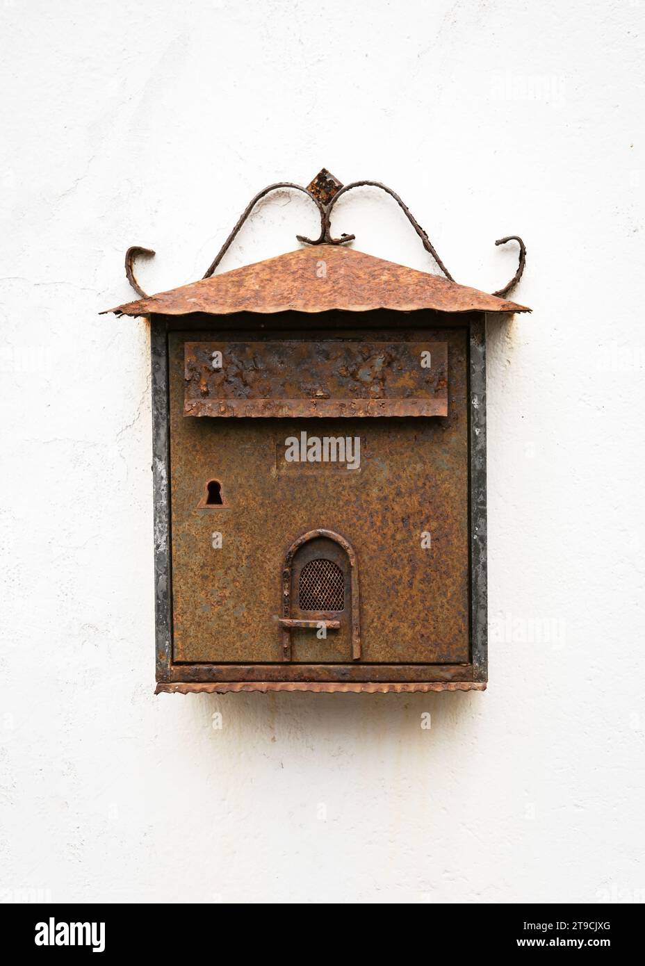 Old vintage rust metal letter box against a white stone wall in El ...