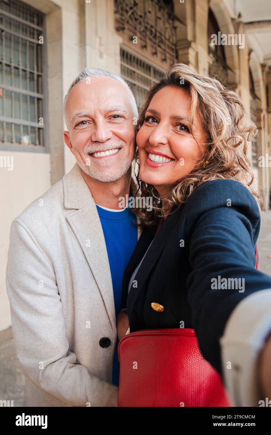 Vertical. Affectionate mid adult married couple having fun taking a ...