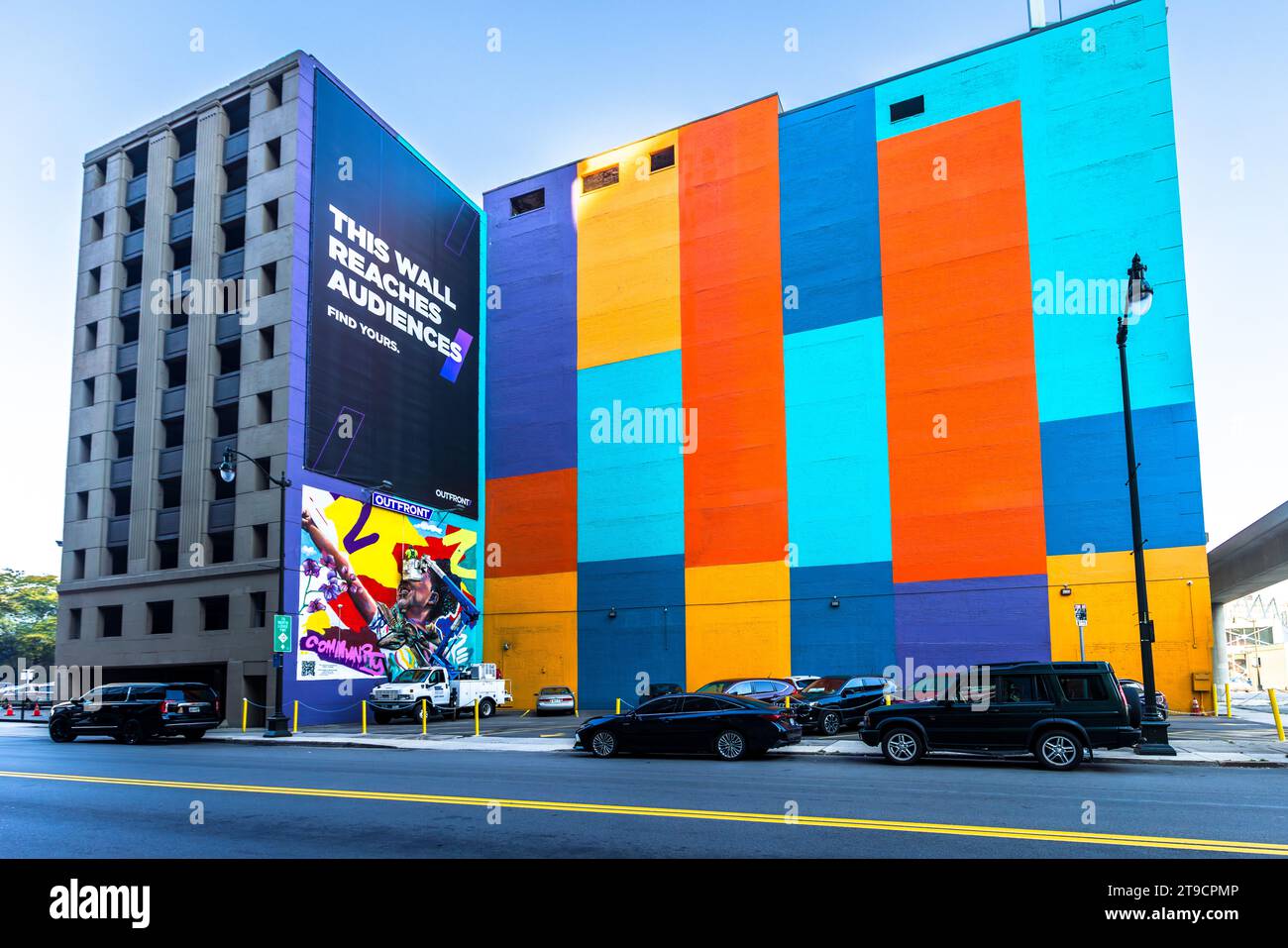 On a riser, a commercial artist paints a house wall in Detroit, United ...