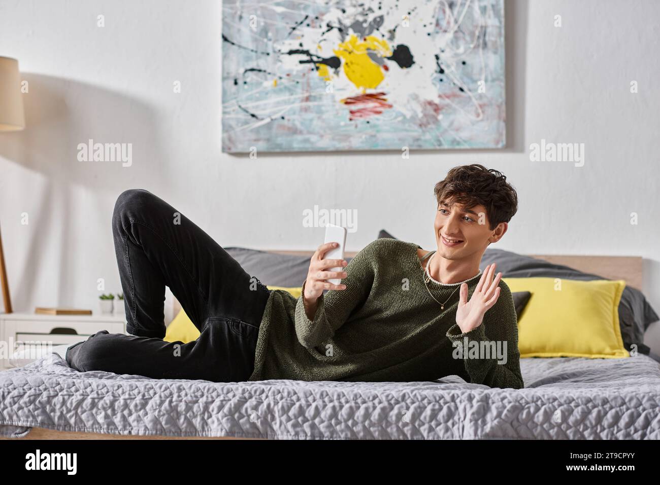 happy and curly transgender social media influencer waving hand during ...