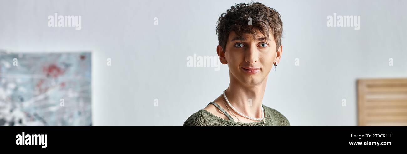 happy transgender person in earring and pearl necklace looking at ...