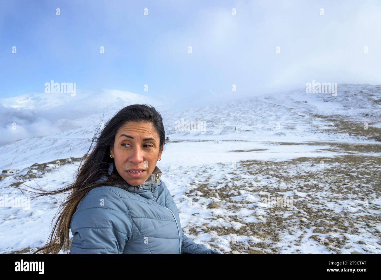 middle-aged latina woman on a snow-capped mountain in a blizzard Stock ...