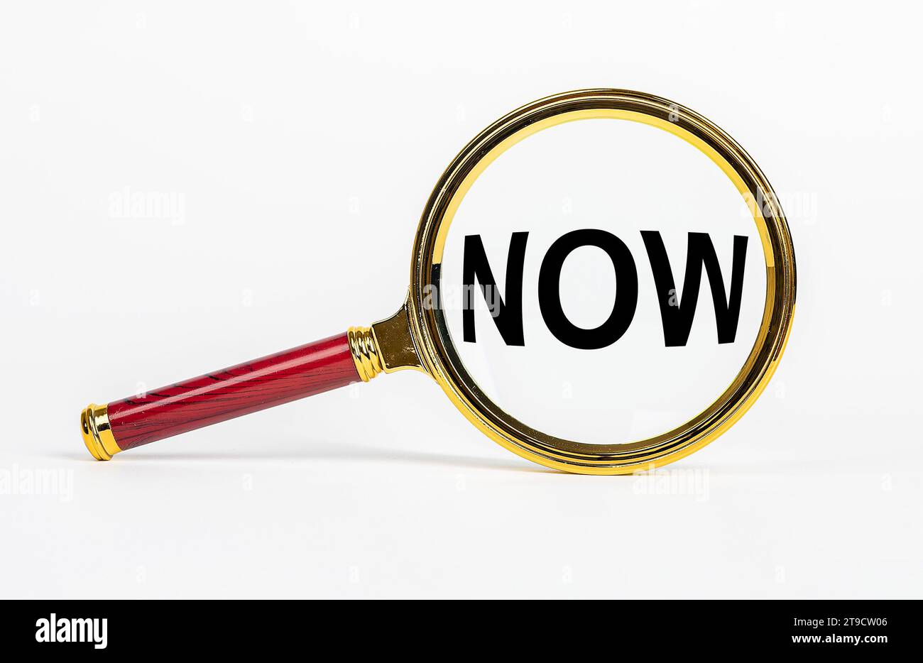 Word NOW through magnifying glass, lens Stock Photo - Alamy