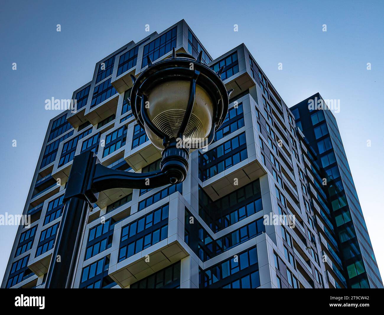 A black street lamp with an ornate light fixture casts illumination ...
