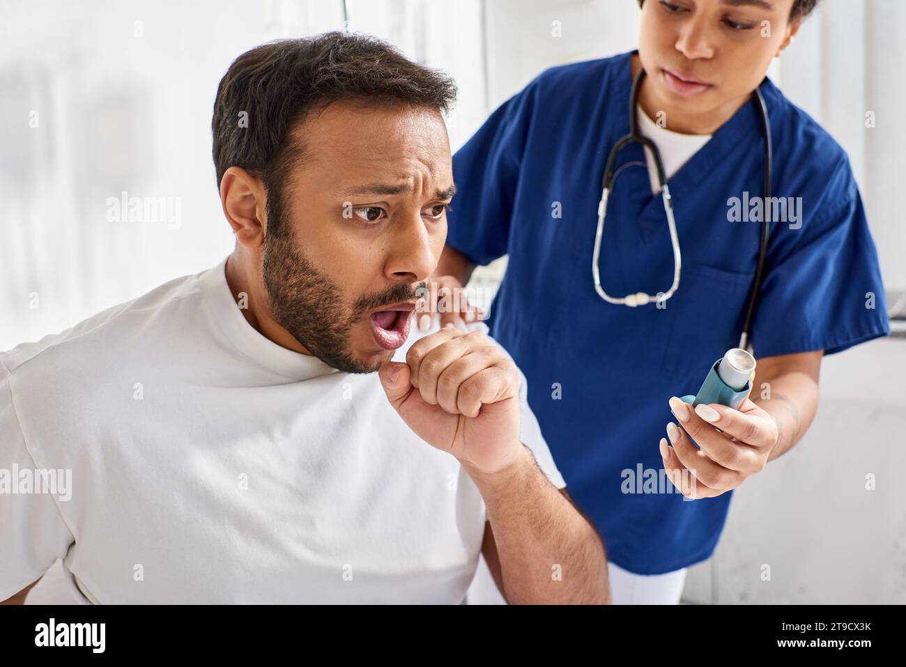young african american nurse giving asthma inhaler to her ill indian ...