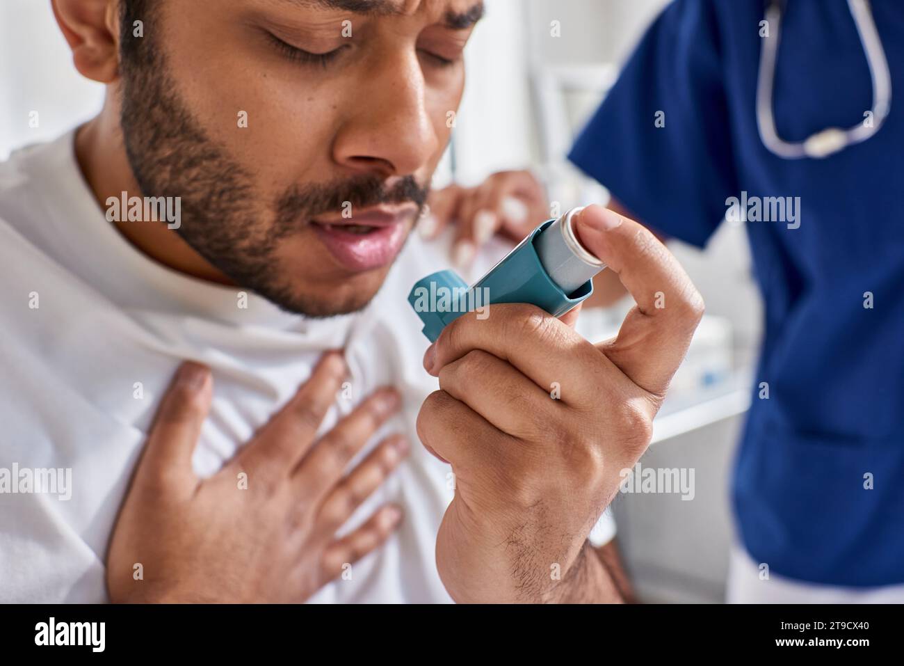 african american nurse helping her indian patient with asthma inhaler ...