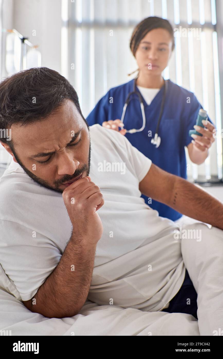 young african american nurse giving asthma inhaler to her ill indian ...
