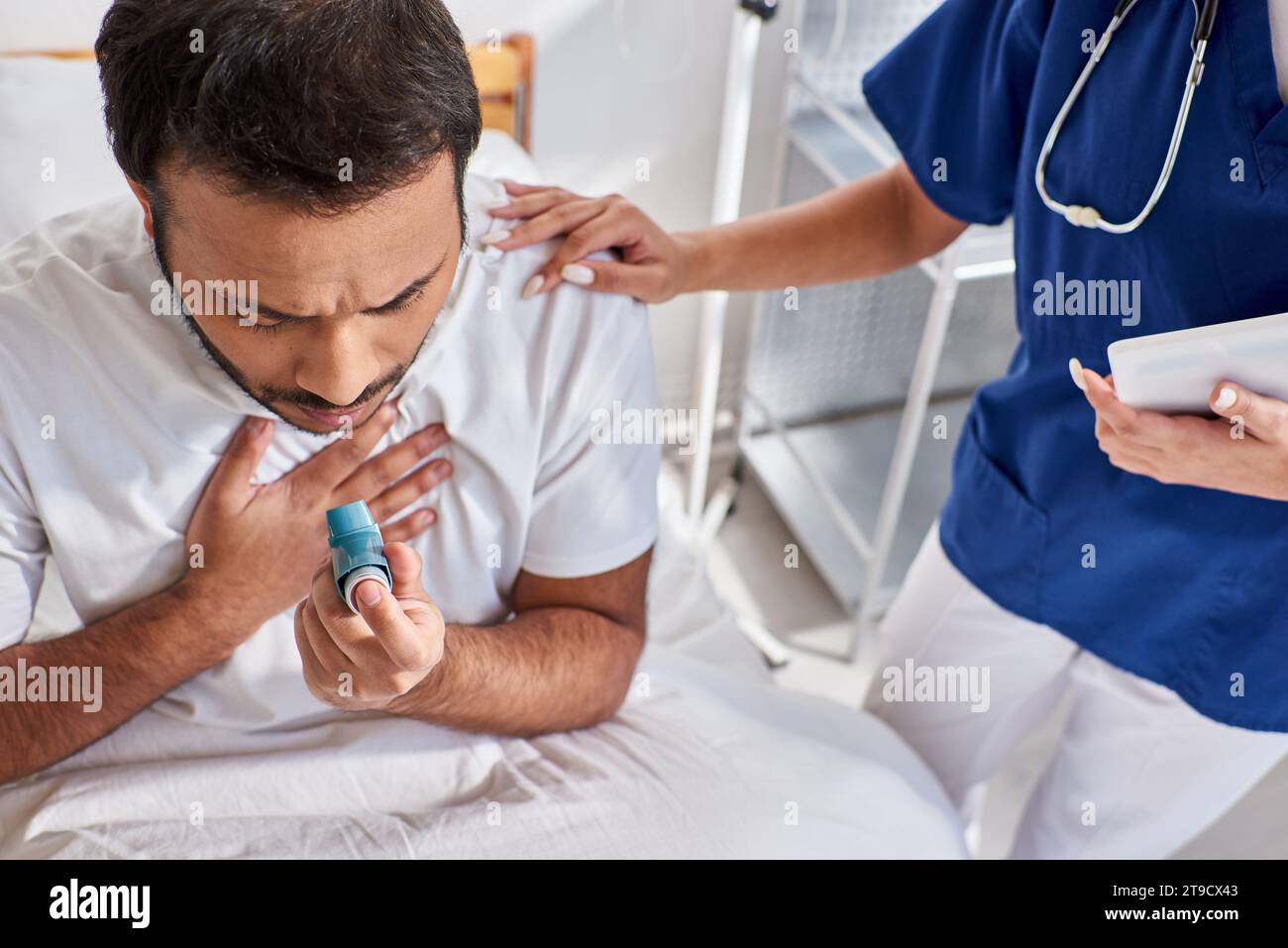 african american nurse helping her indian patient with asthma inhaler ...