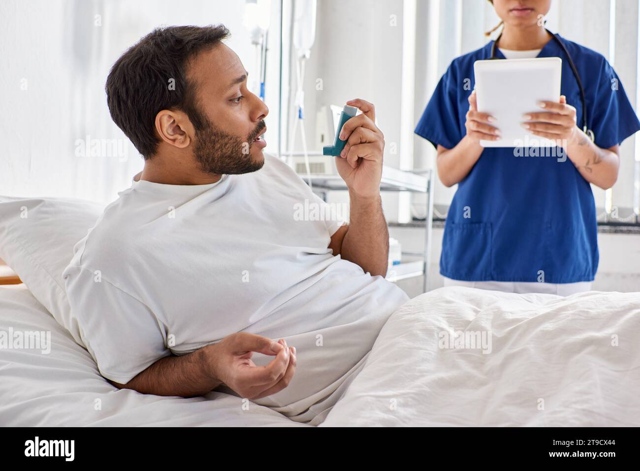 cropped view of indian man using asthma inhaler with blurred nurse on ...
