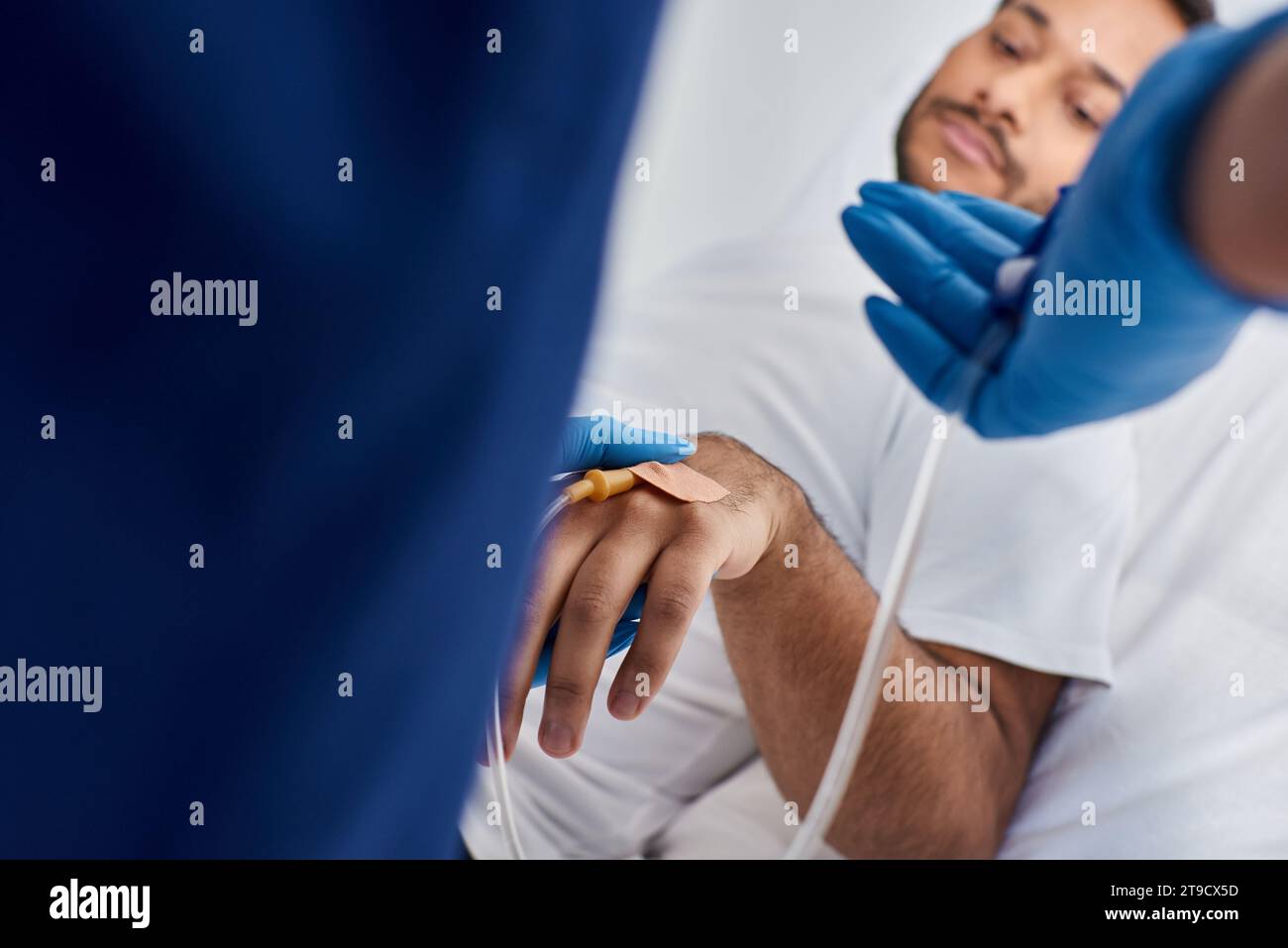 cropped view of african american nurse inserting catheter into arm of ...