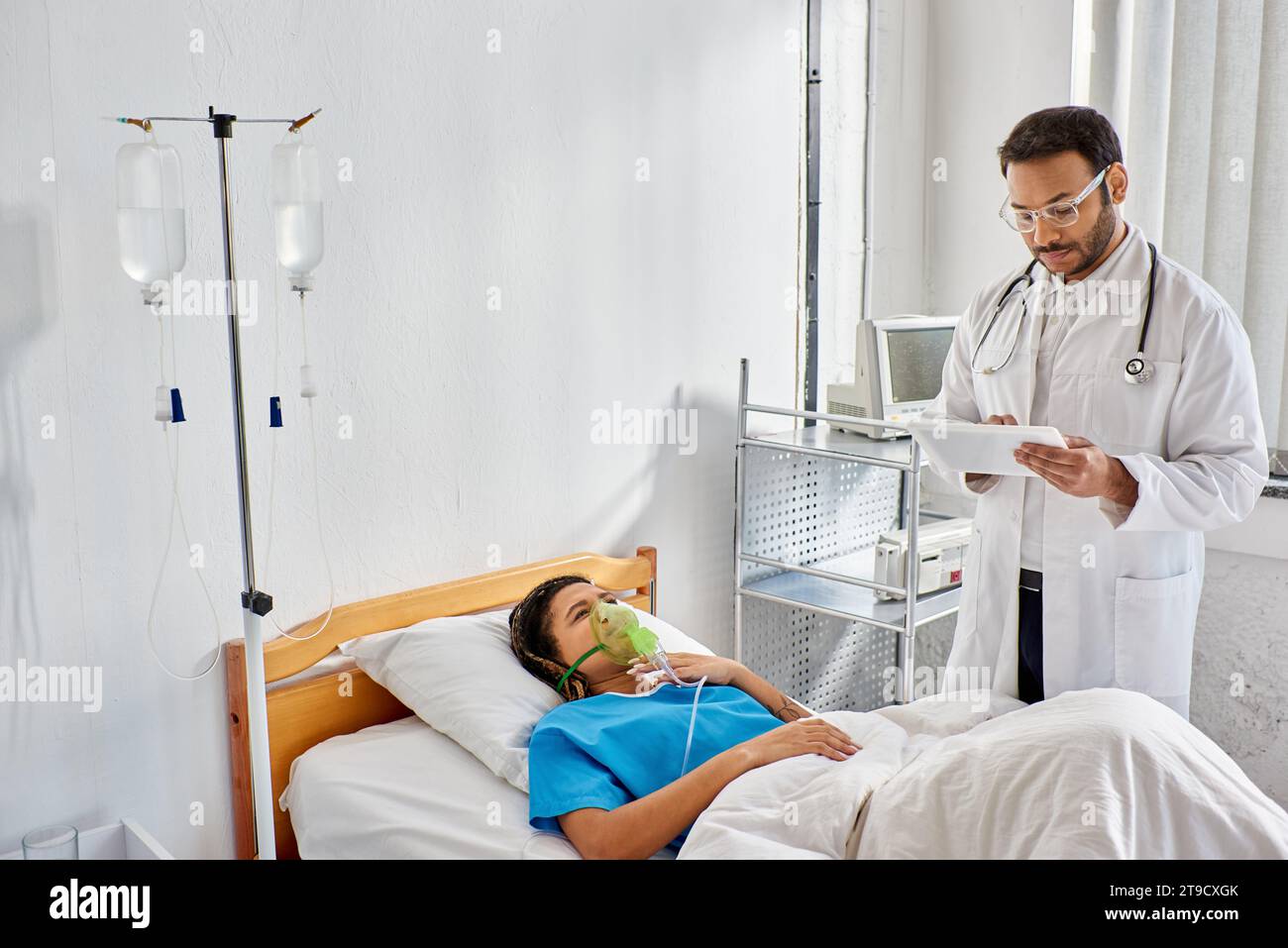 young indian doctor helping his sick african american female patient ...