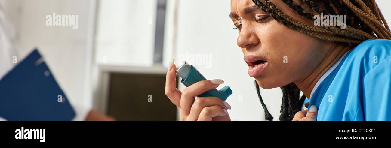 focus on ill african american patient using her inhaler next to her ...