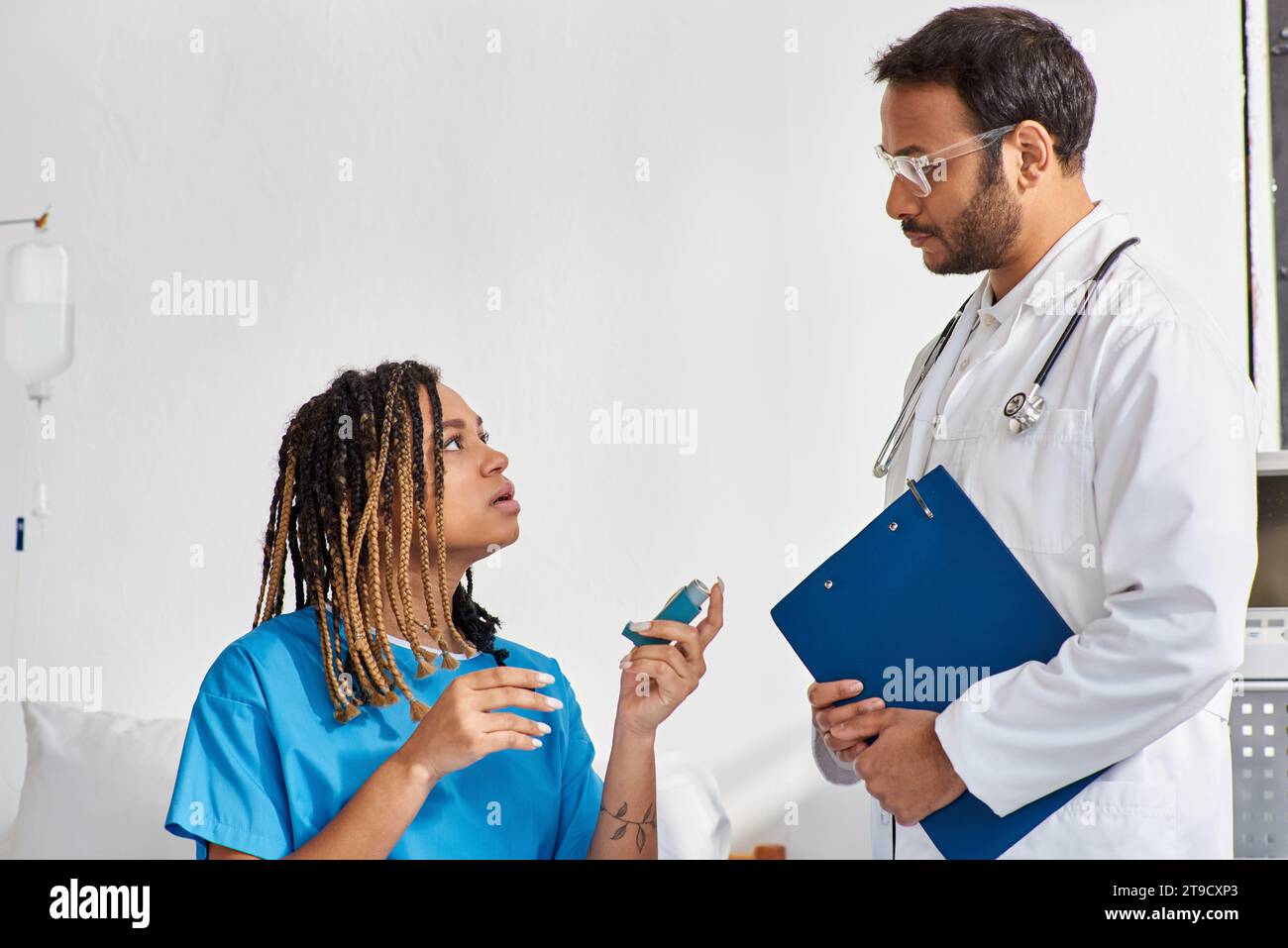 young indian doctor teaching his ill african american female patient ...
