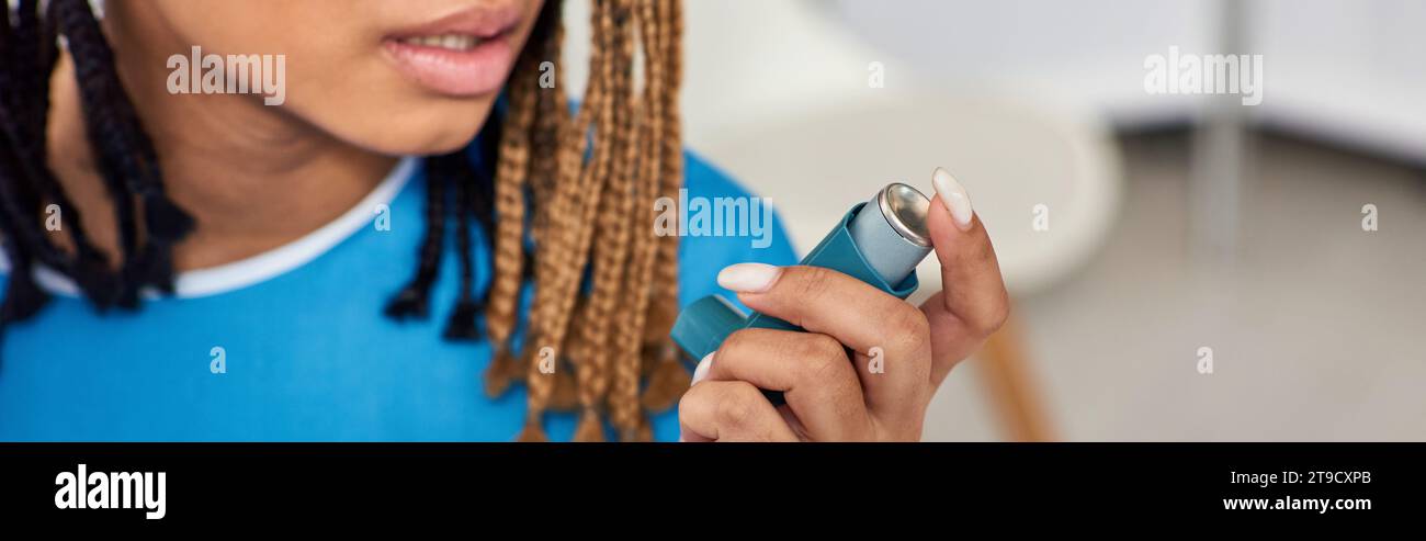 ill african american patient using her asthma inhaler in hospital ward ...