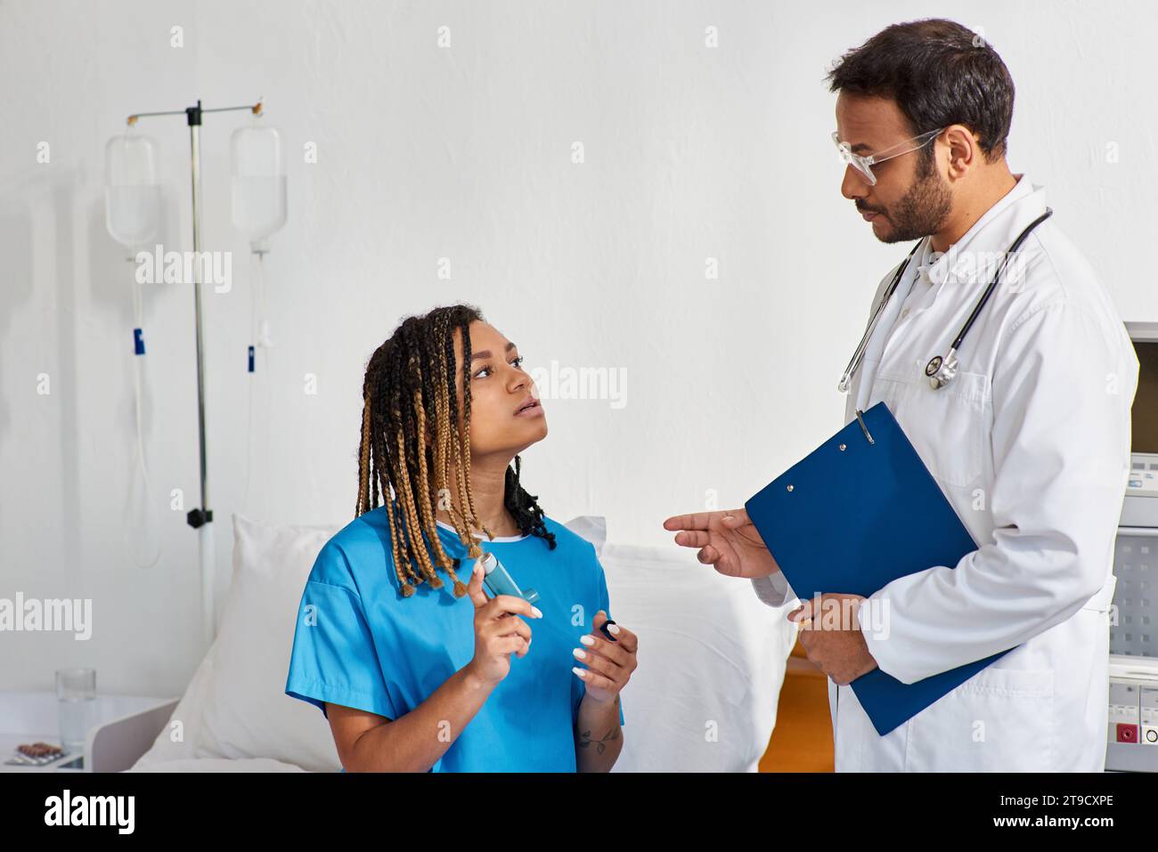 young indian doctor teaching his ill african american female patient ...