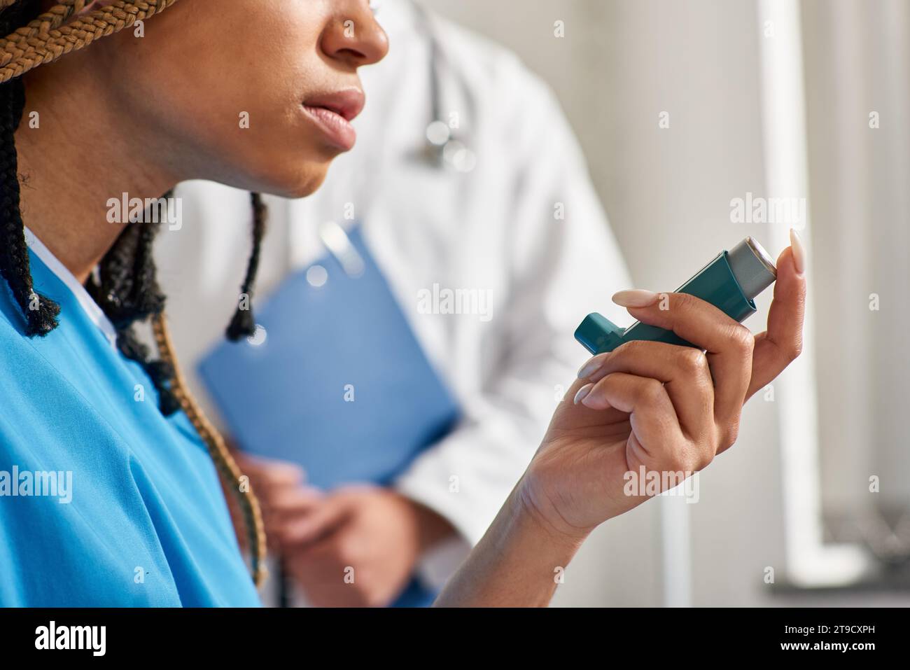 cropped view of young african american woman using her inhaler with ...