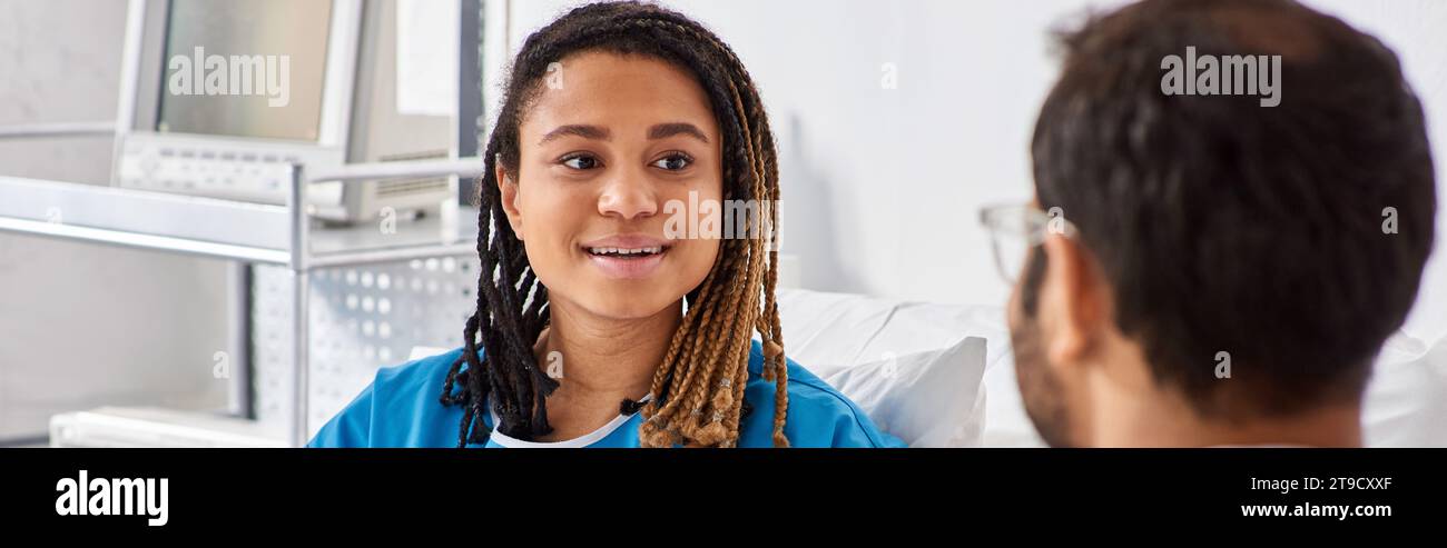 focus on young jolly african american woman looking at her blurred ...