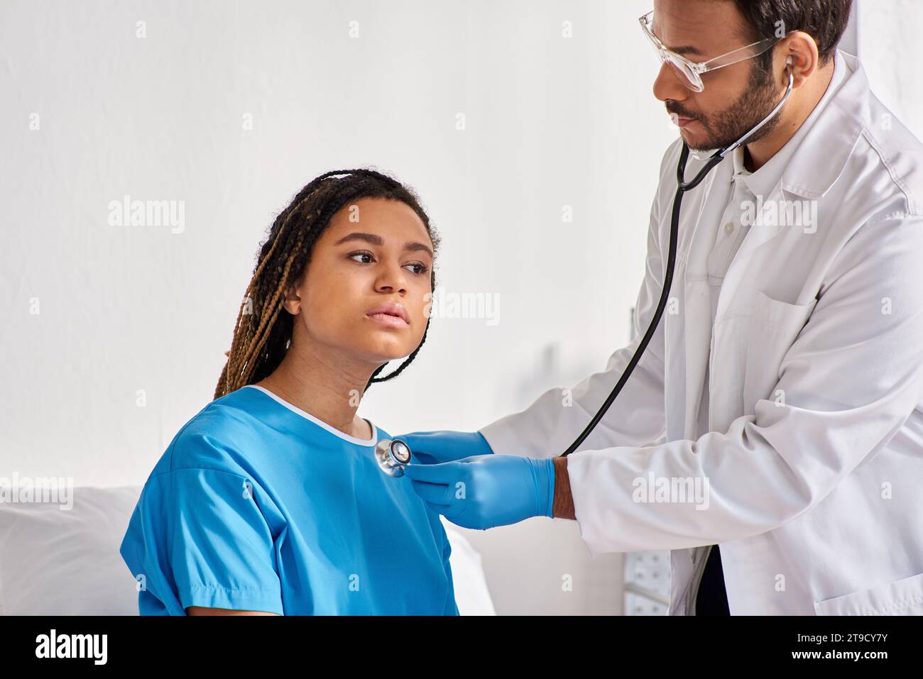 indian doctor checking breath of his african american female patient in ...