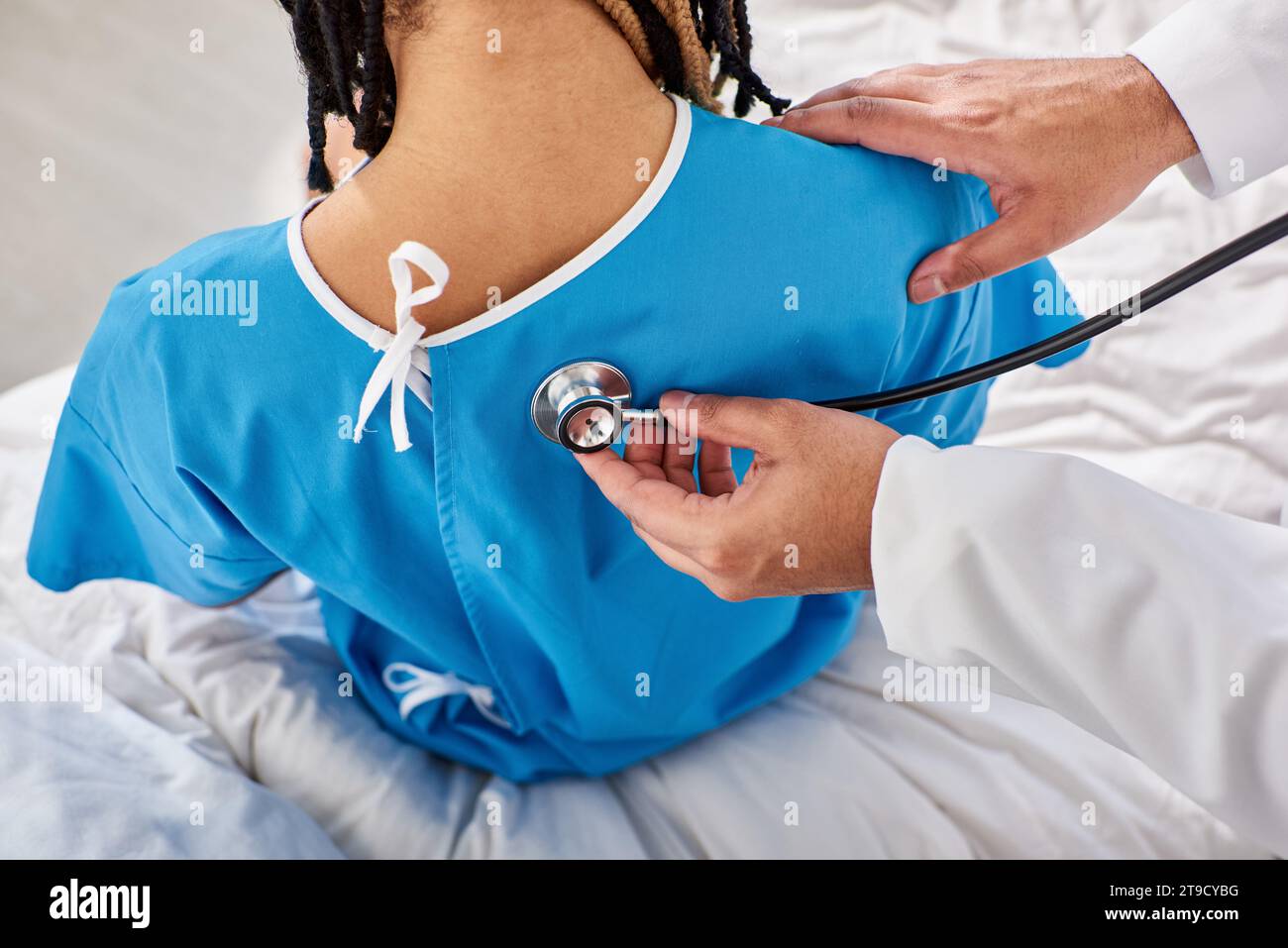 back view of indian doctor checking breath of his african american ...